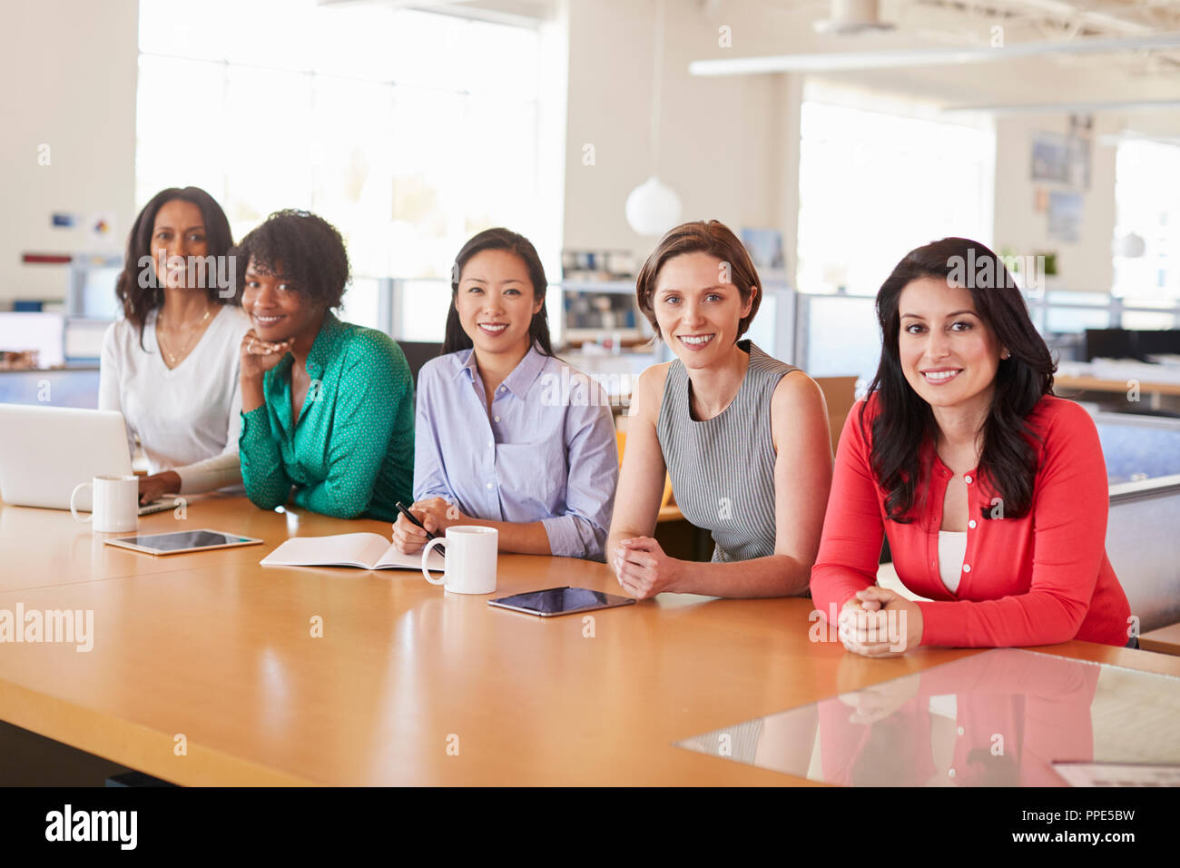 Female business colleagues in an office smiling to camera Stock Photo ...
