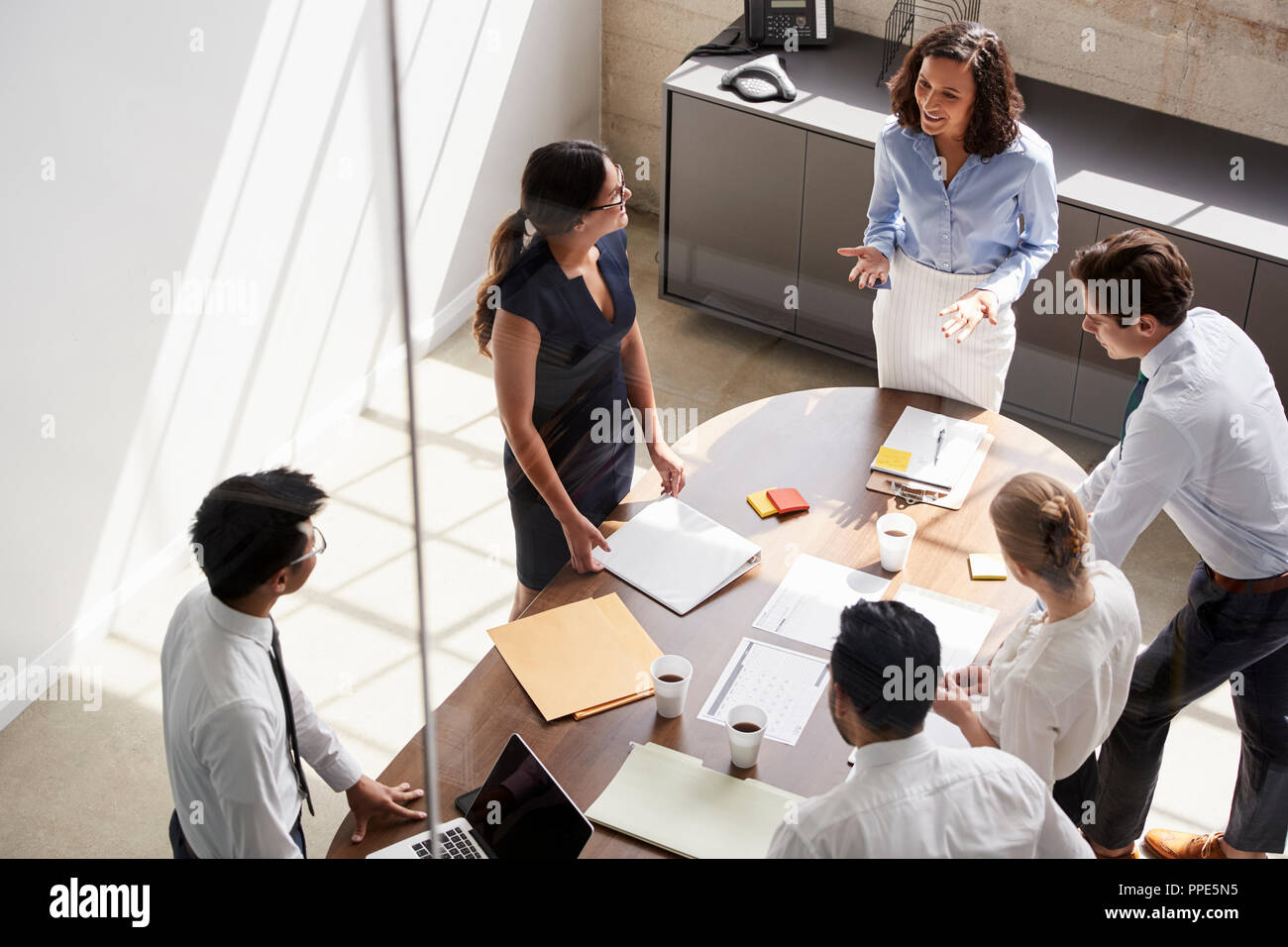Female manager in team meeting, elevated view through window Stock ...