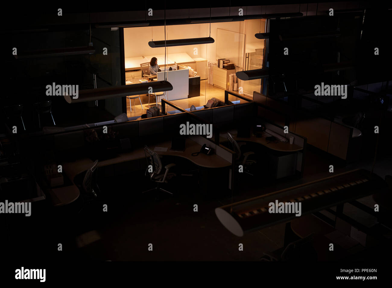 Office worker working late in an otherwise dark office Stock Photo - Alamy