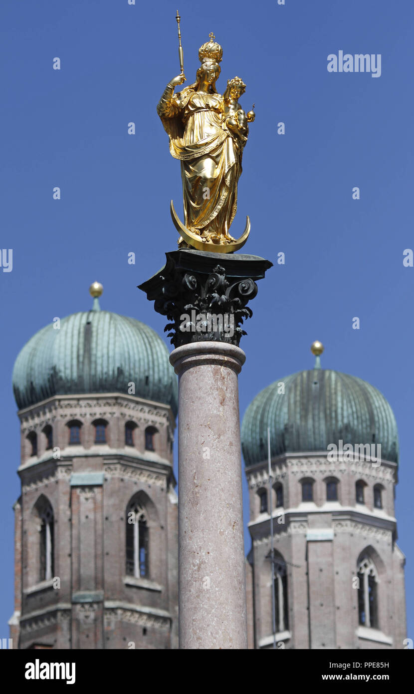 Virgin Mary atop the Mariensäule in Munich with the towers of the ...