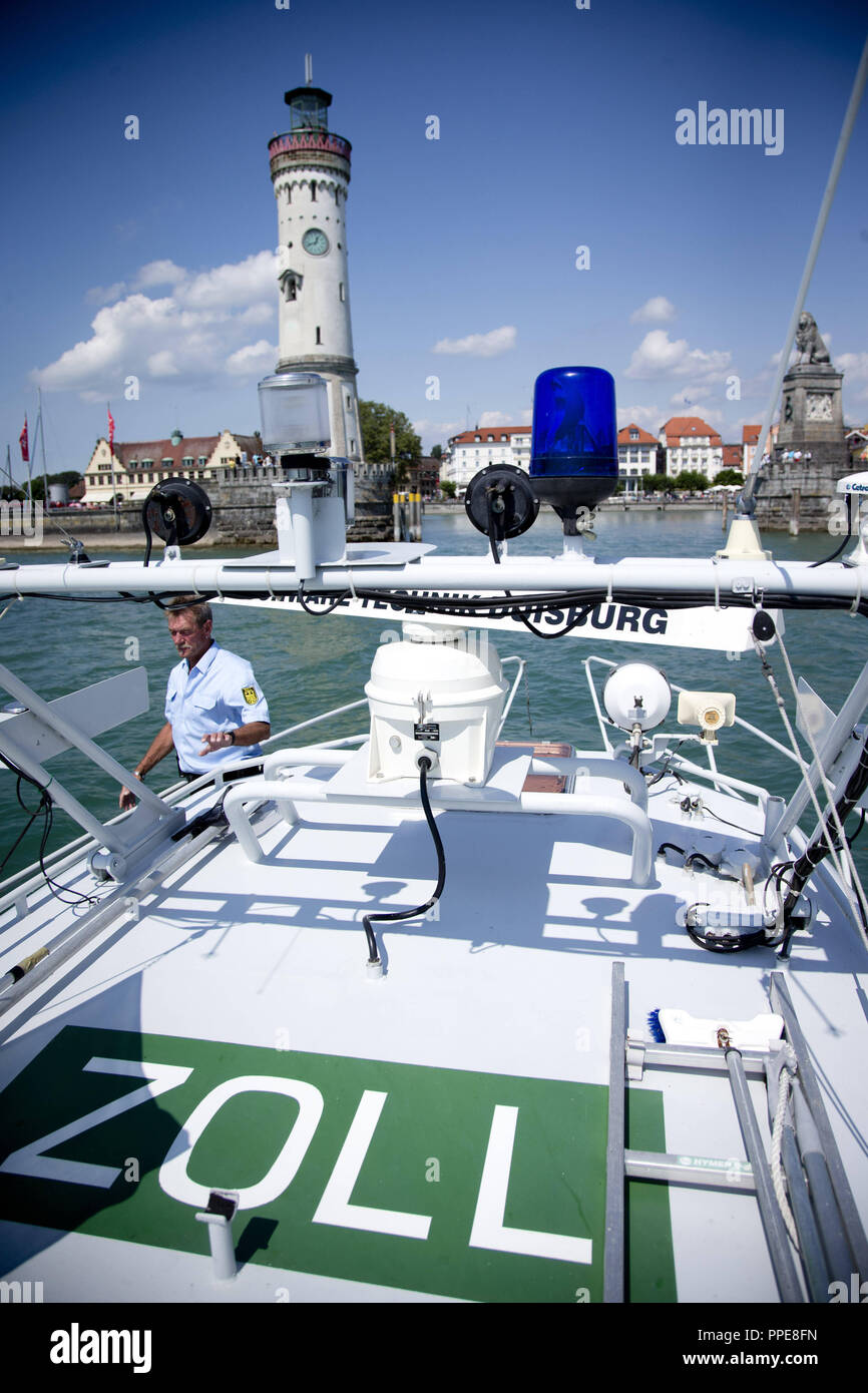 Customs boat in the harbor entrance of Lindau. In the background, the ...