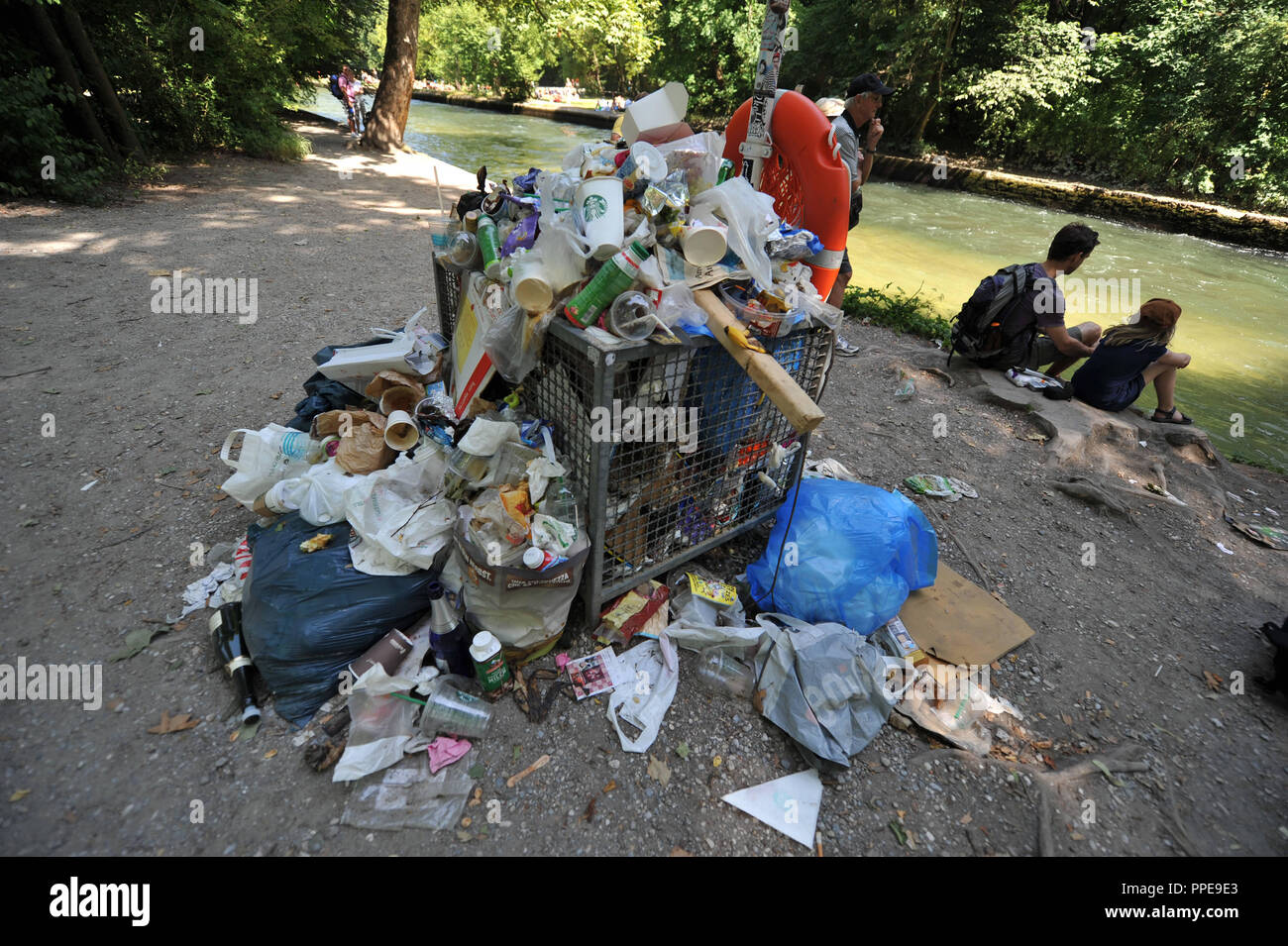 Overflowing waste container at the Eisbach River in the English Garden ...