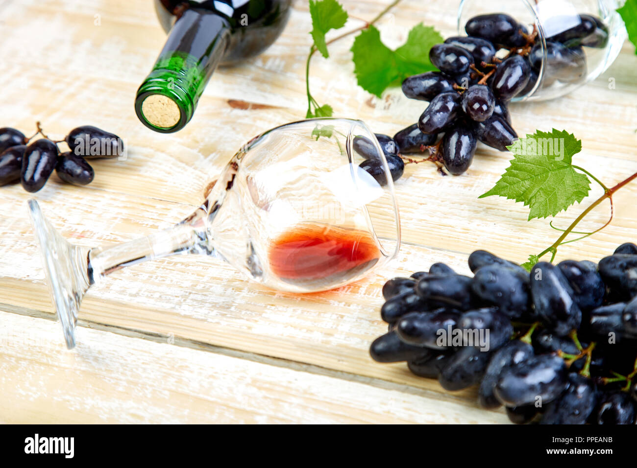 Red wine concept with bottle, glass and grapes on wooden background ...
