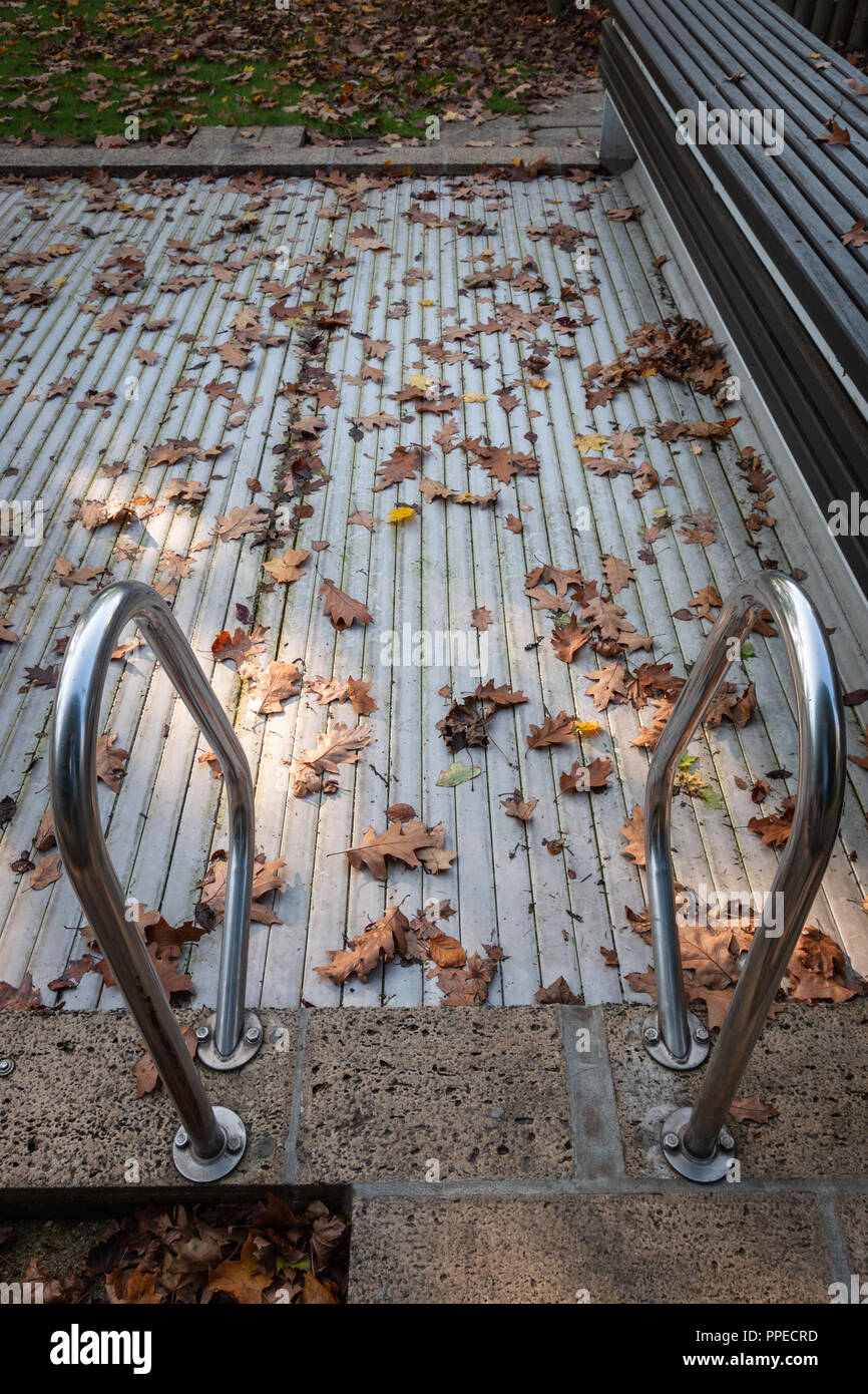 Closes swimming pool with coloful leaves on the cover in autumn ...