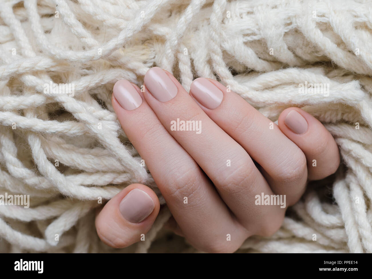 Beautiful female hand with beige nail design Stock Photo - Alamy