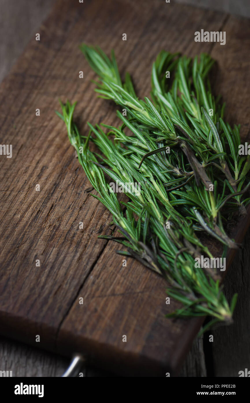 Fresh rosemary bunch on dark wooden background Stock Photo - Alamy