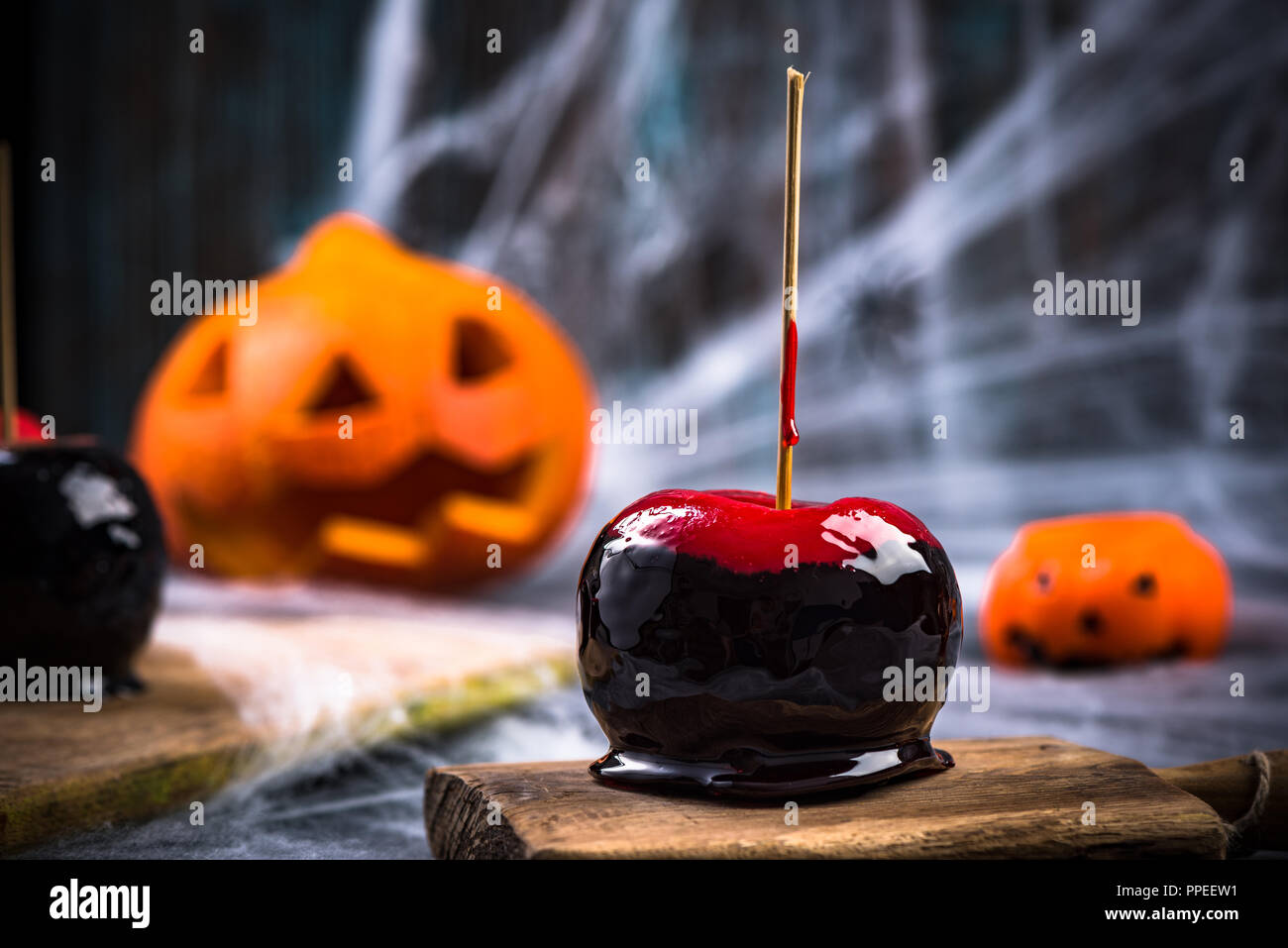 Red and black candy glazed apple, Halloween snack Stock Photo - Alamy