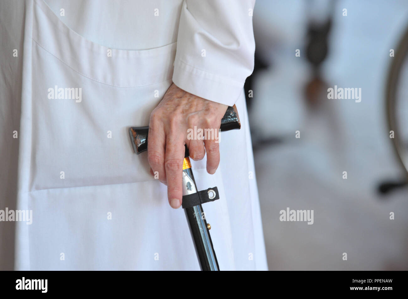 A white-robed nun with a walking stick in the retirement and nursing ...