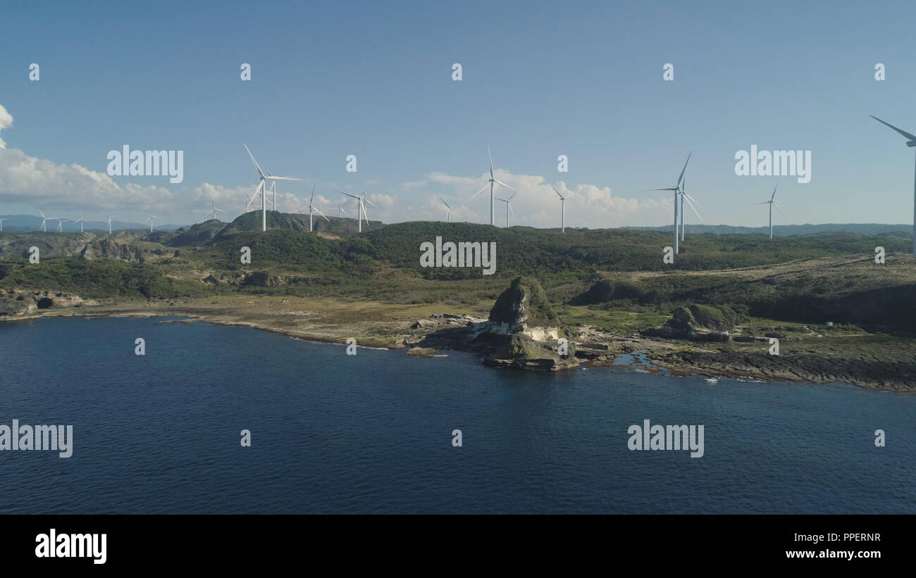 Natural rock formation of limestone stone on the coast with windmills ...