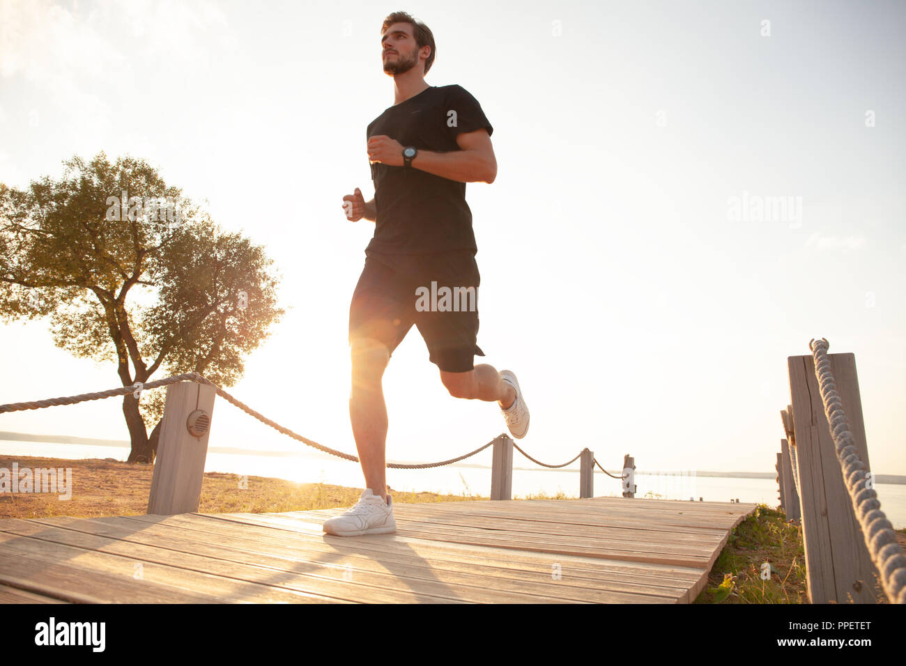 Full length shot of healthy young man running on the promenade. Male ...