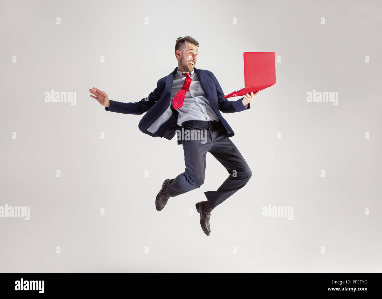 Image of young surprised man over white studio using laptop computer ...