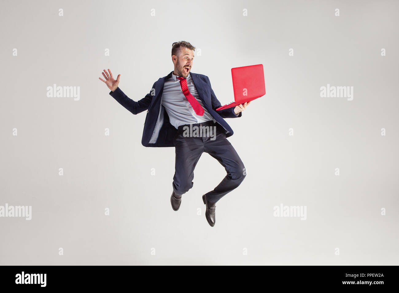Image of young surprised man over white studio using laptop computer ...