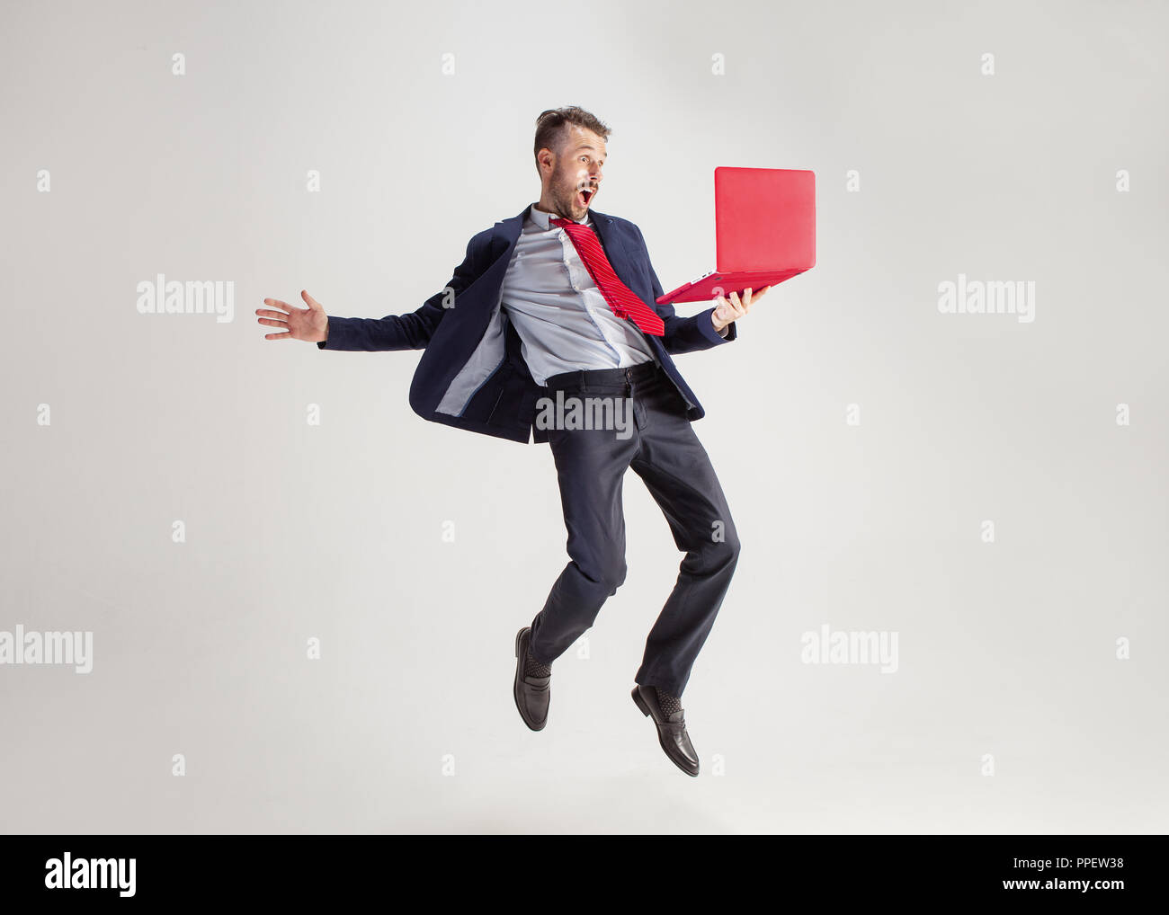 Image of young surprised man over white studio using laptop computer ...