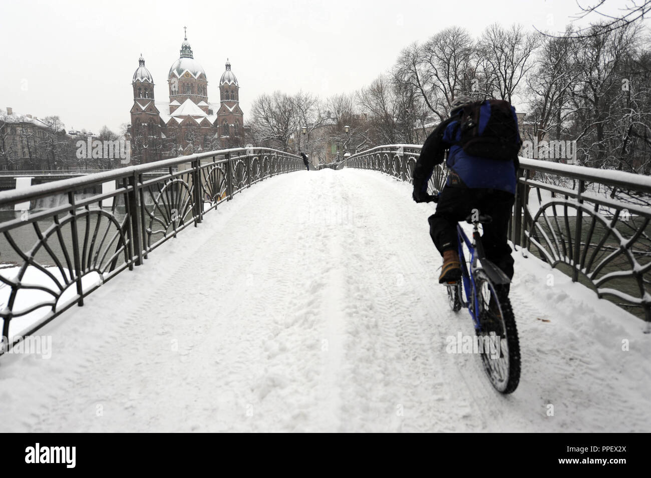 Biker on the snow-covered Kabelsteg, in the background the St. Lukas ...