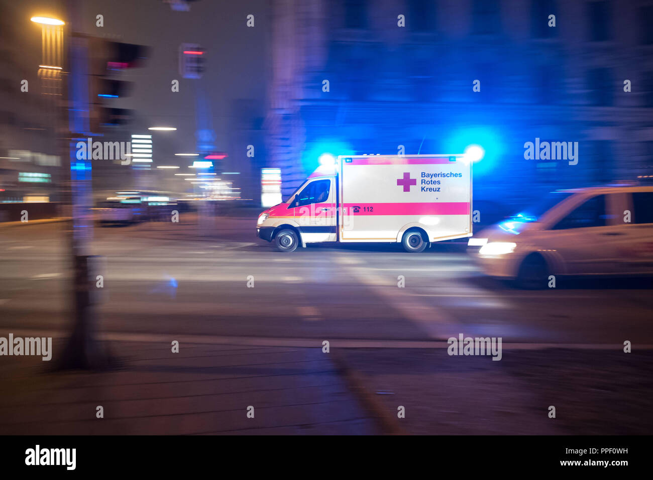 A rescue vehicle of the Bavarian Red Cross (BRK) drives with switched ...