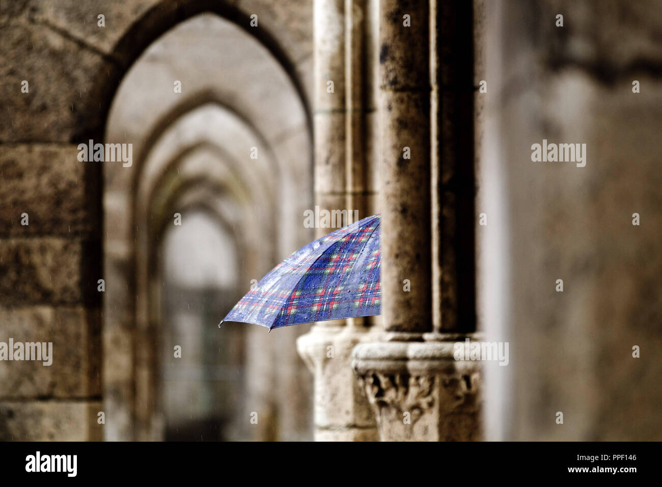 Visitors with umbrella in the Gothic walkway around the cathedral on ...