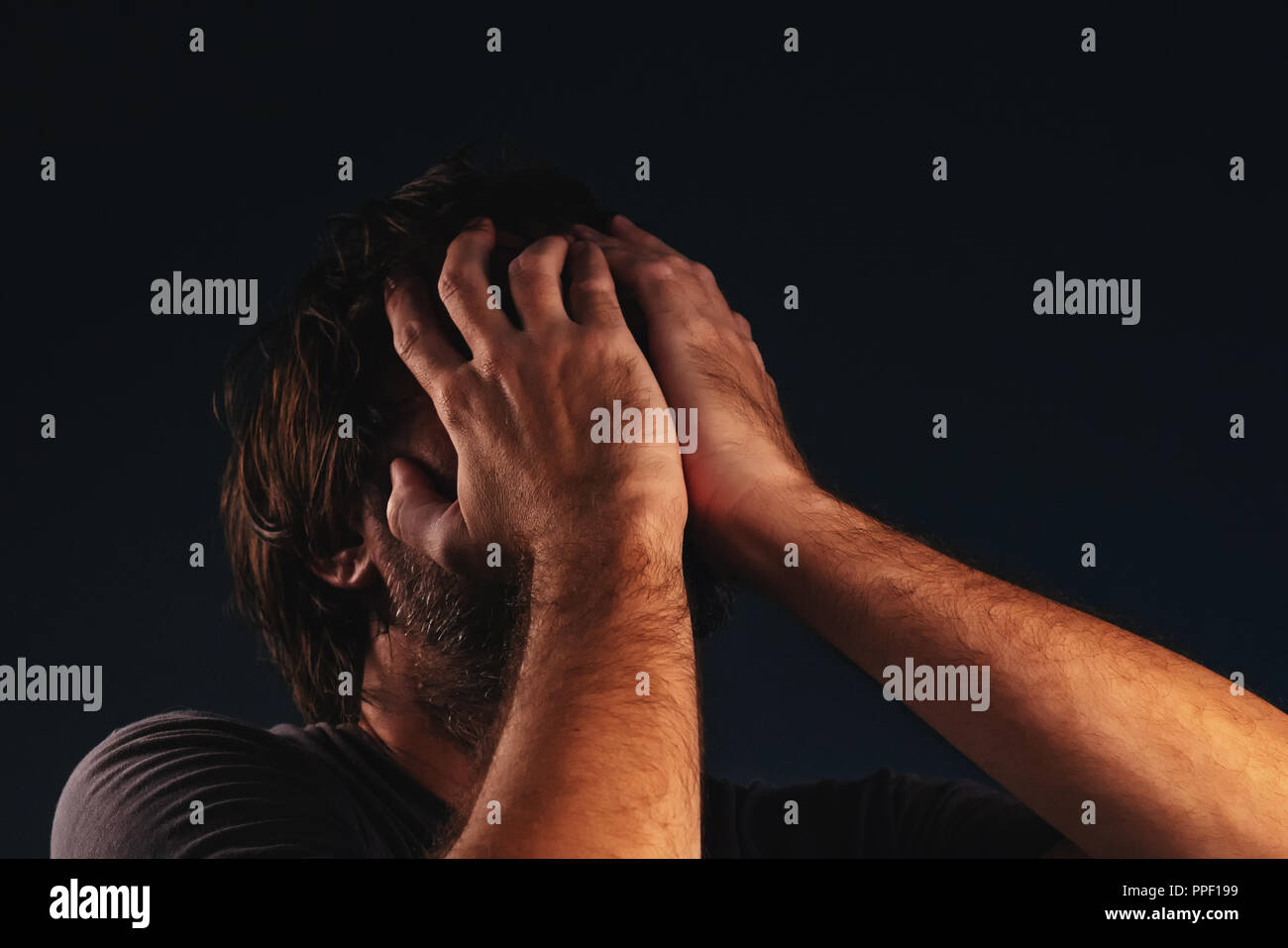 Man is crying in despair, hands covering face, low key portrait Stock ...