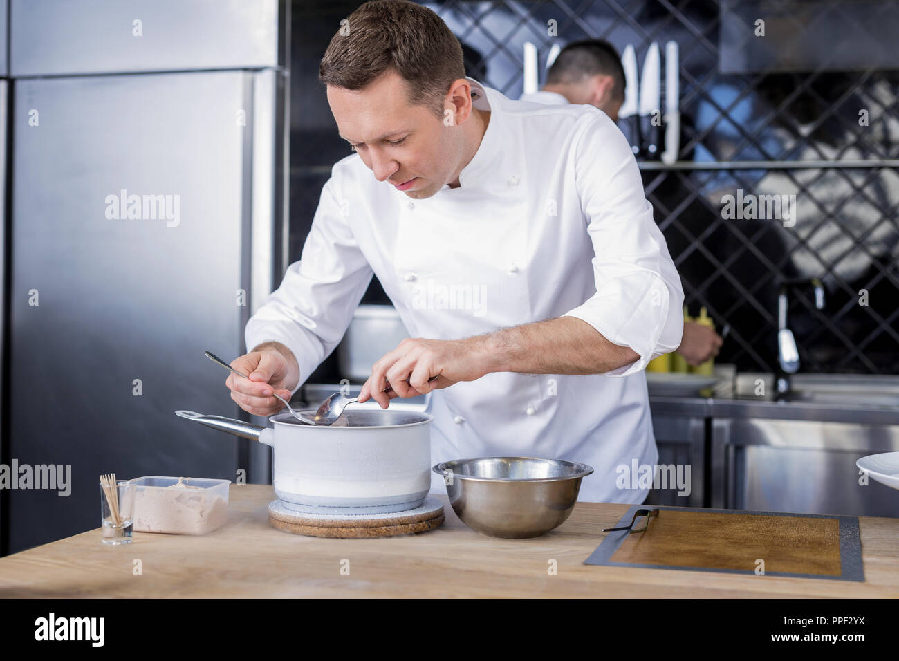 Concentrated cook preparing something delicious in the kitchen Stock ...