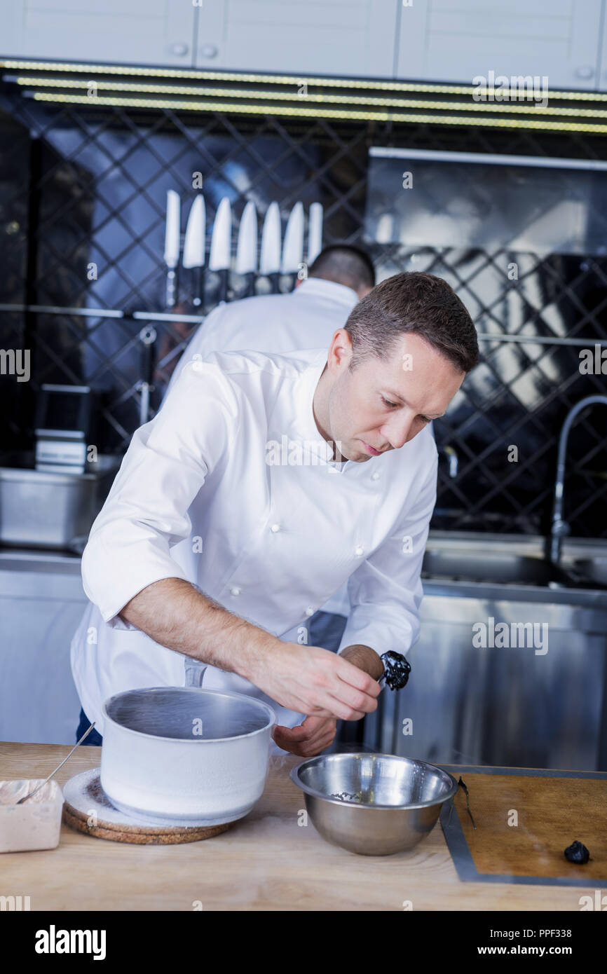 Concentrated cook preparing a wonderful dinner in the kitchen Stock ...