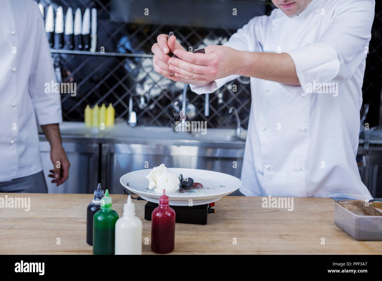 Talented cooks adding the last ingredient to a dish Stock Photo - Alamy