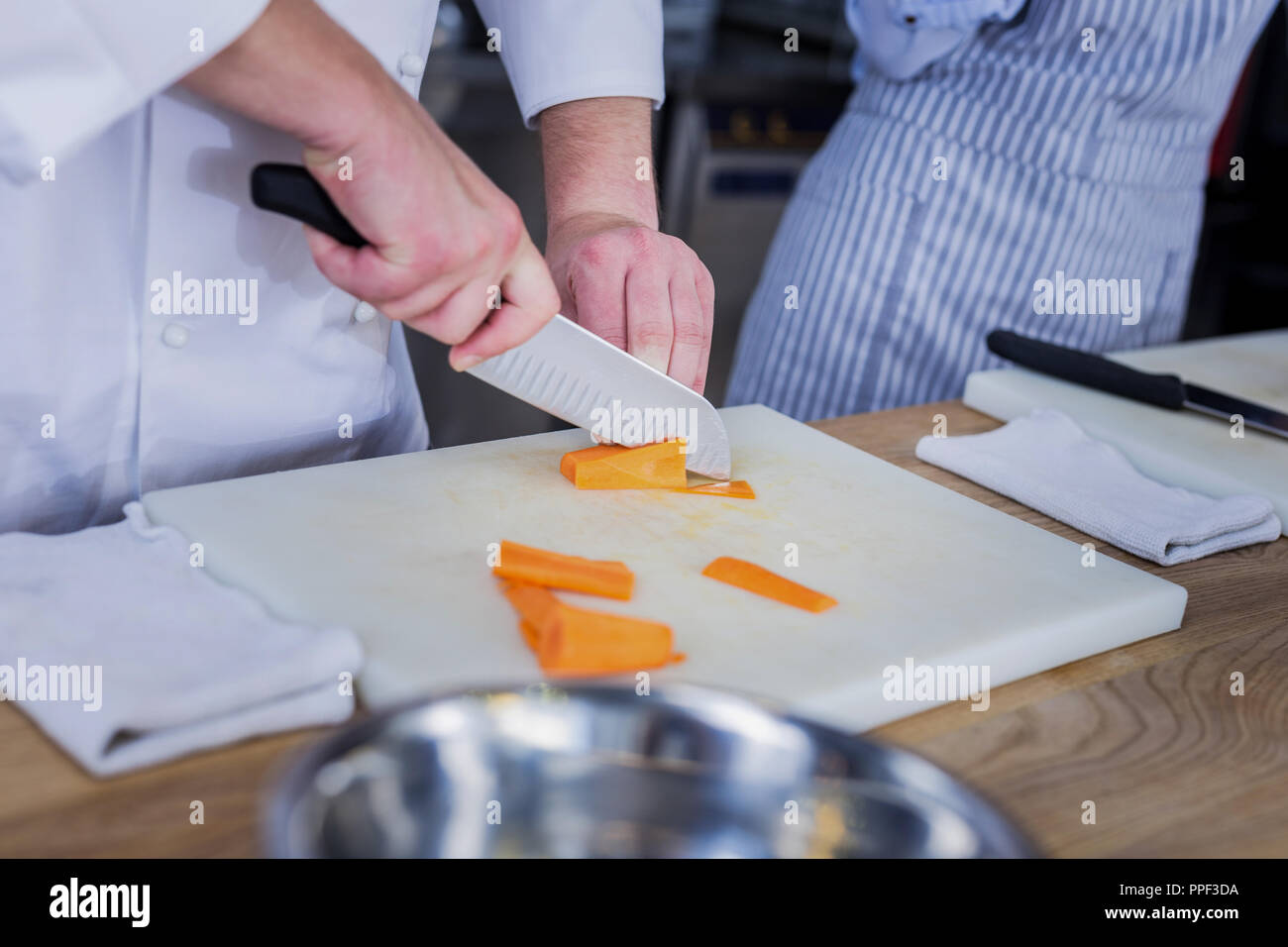 Experienced cook cutting ingredients for a dish Stock Photo - Alamy