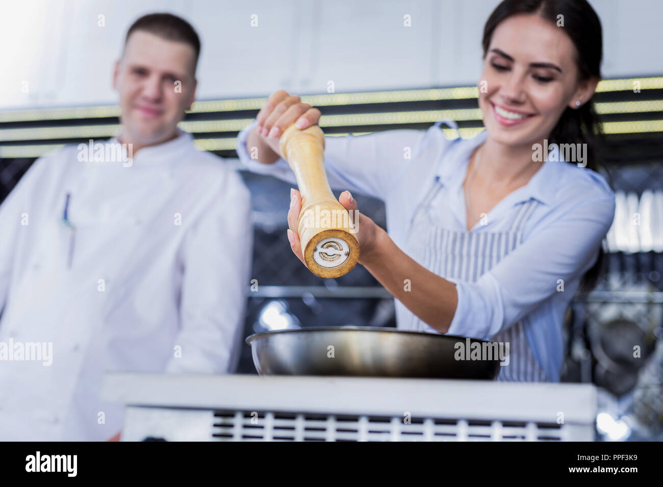 Young cook adding important spices to a dish Stock Photo - Alamy