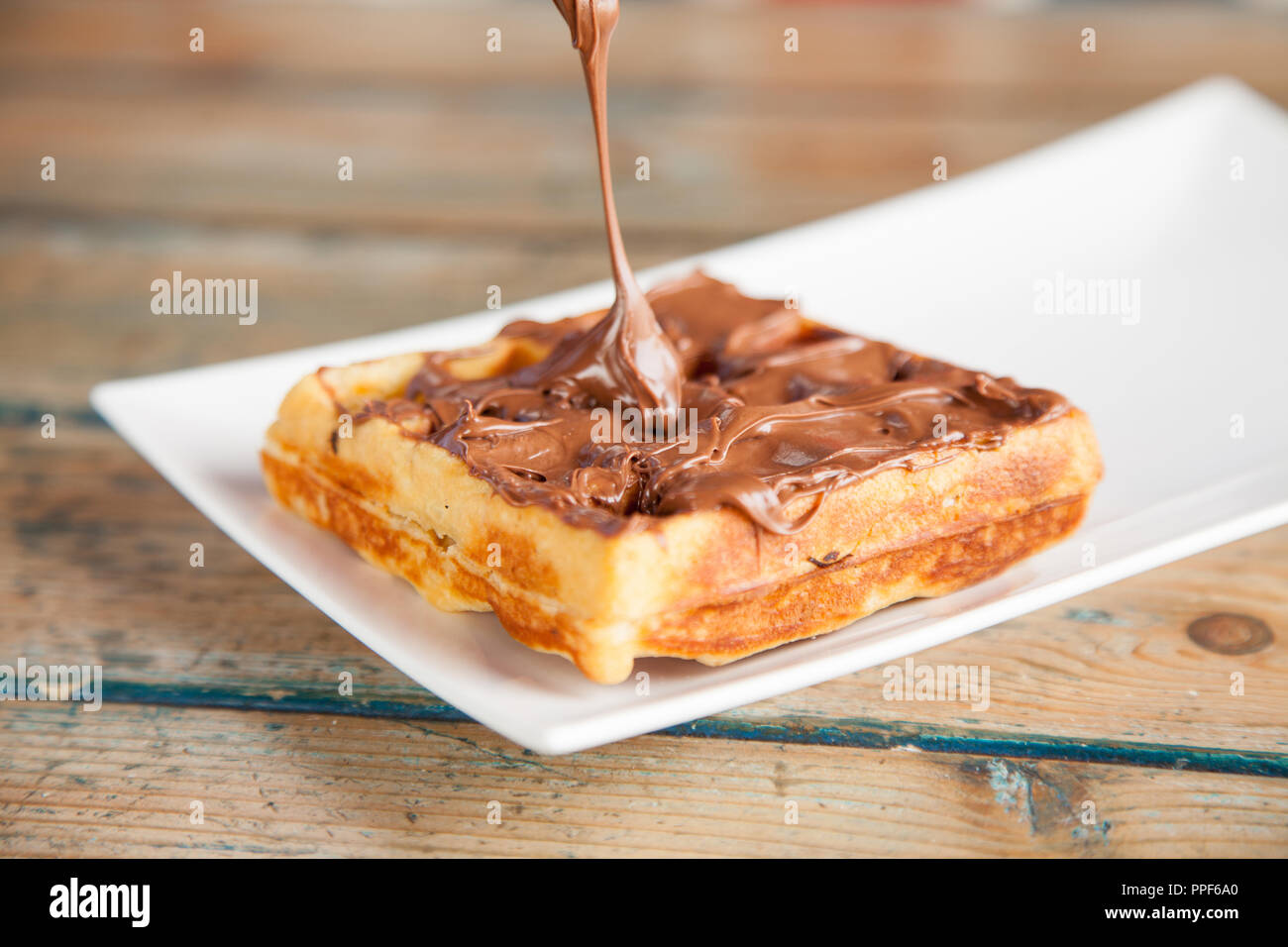 Dripping Nutella waffle pancake chocolate snack Stock Photo - Alamy