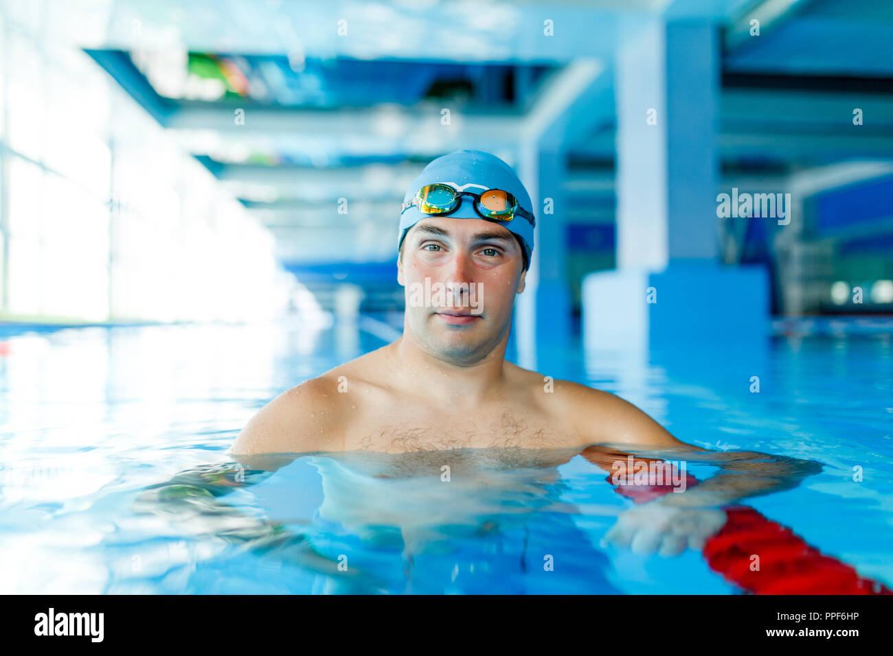 Photo of sports swimmer standing in water at pool during workout Stock ...