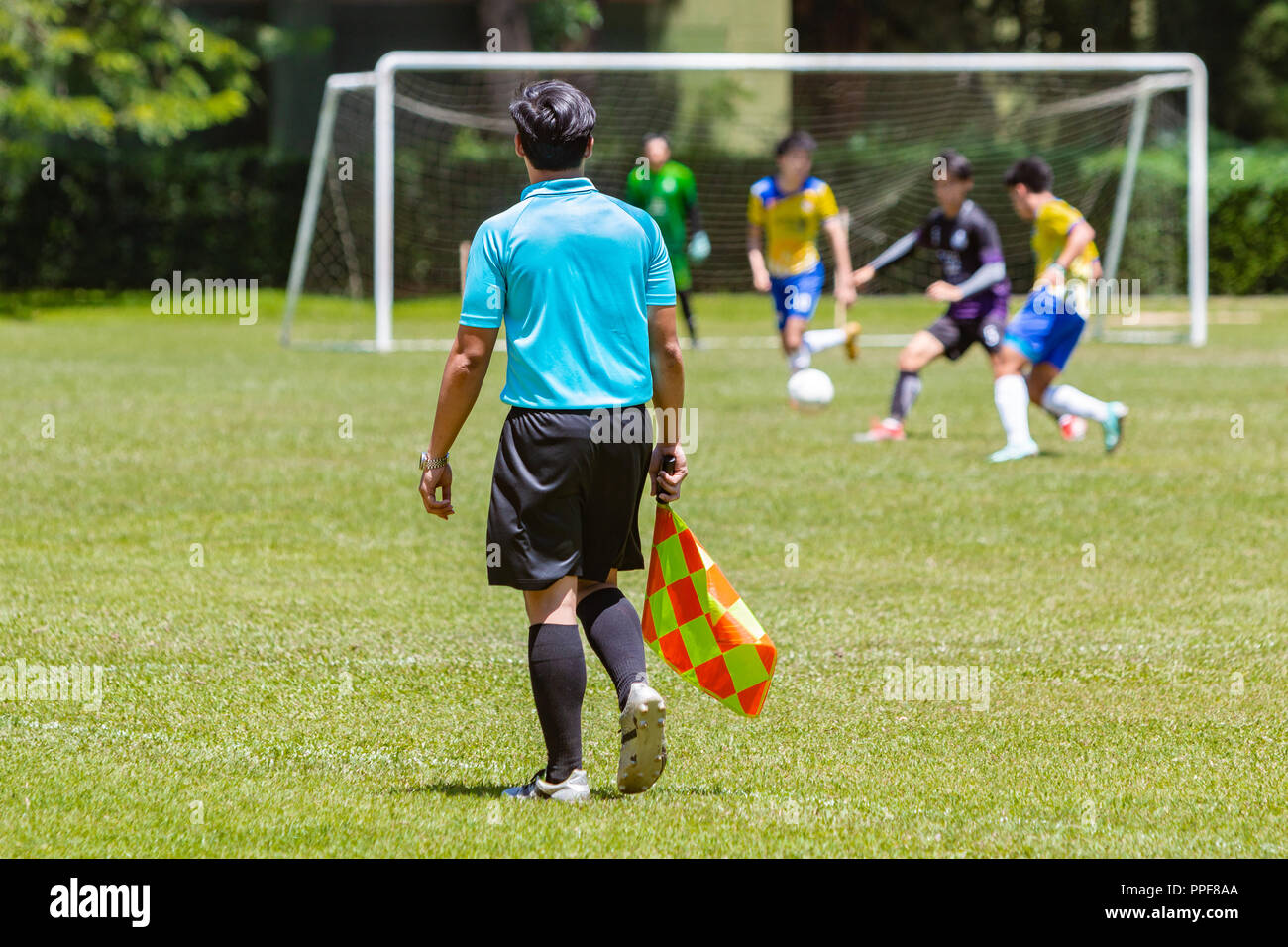 Soccer or football lineman referee watching action in a boy youth game ...