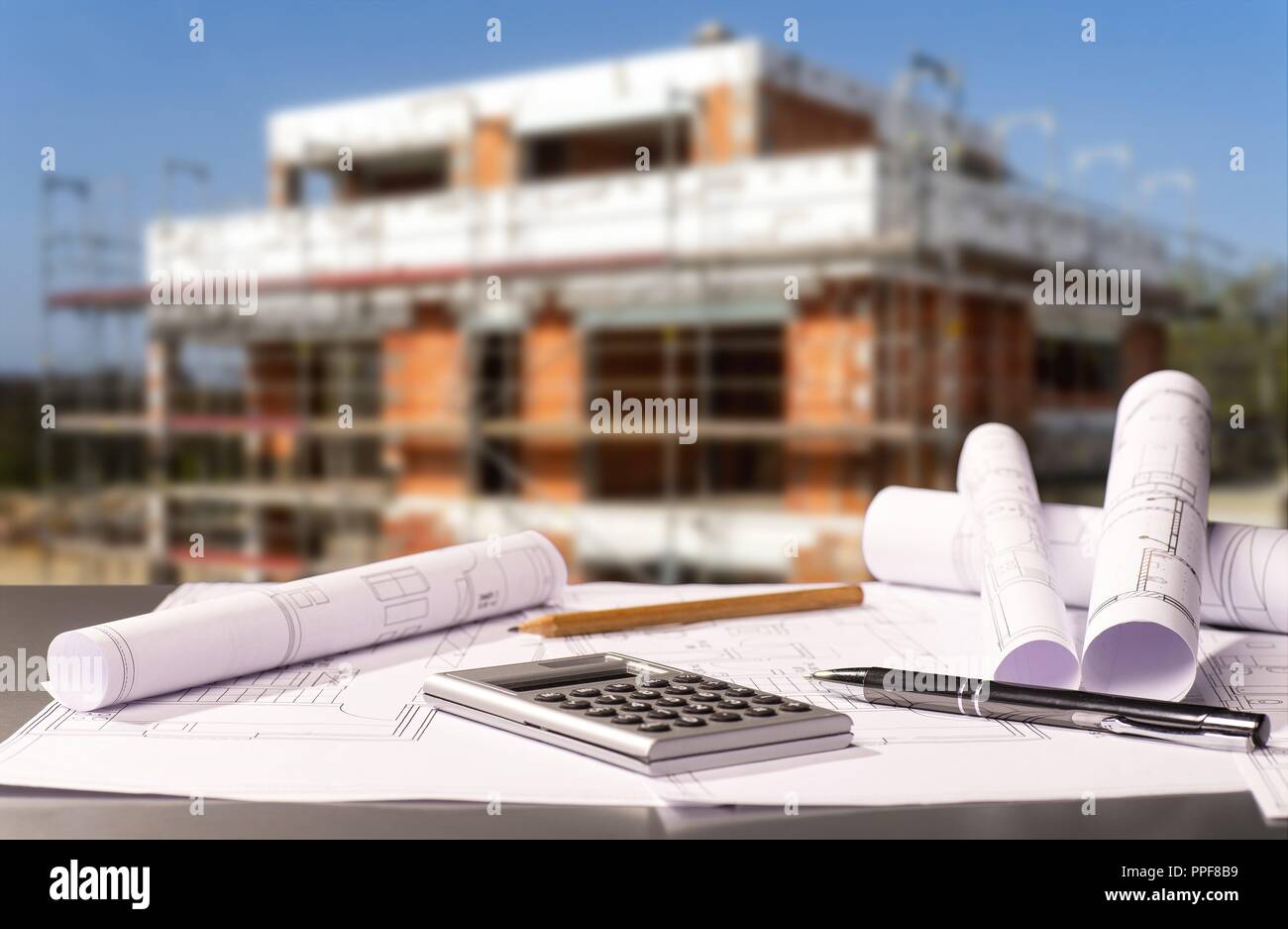 Construction plans with calculator and a shell in the background ...