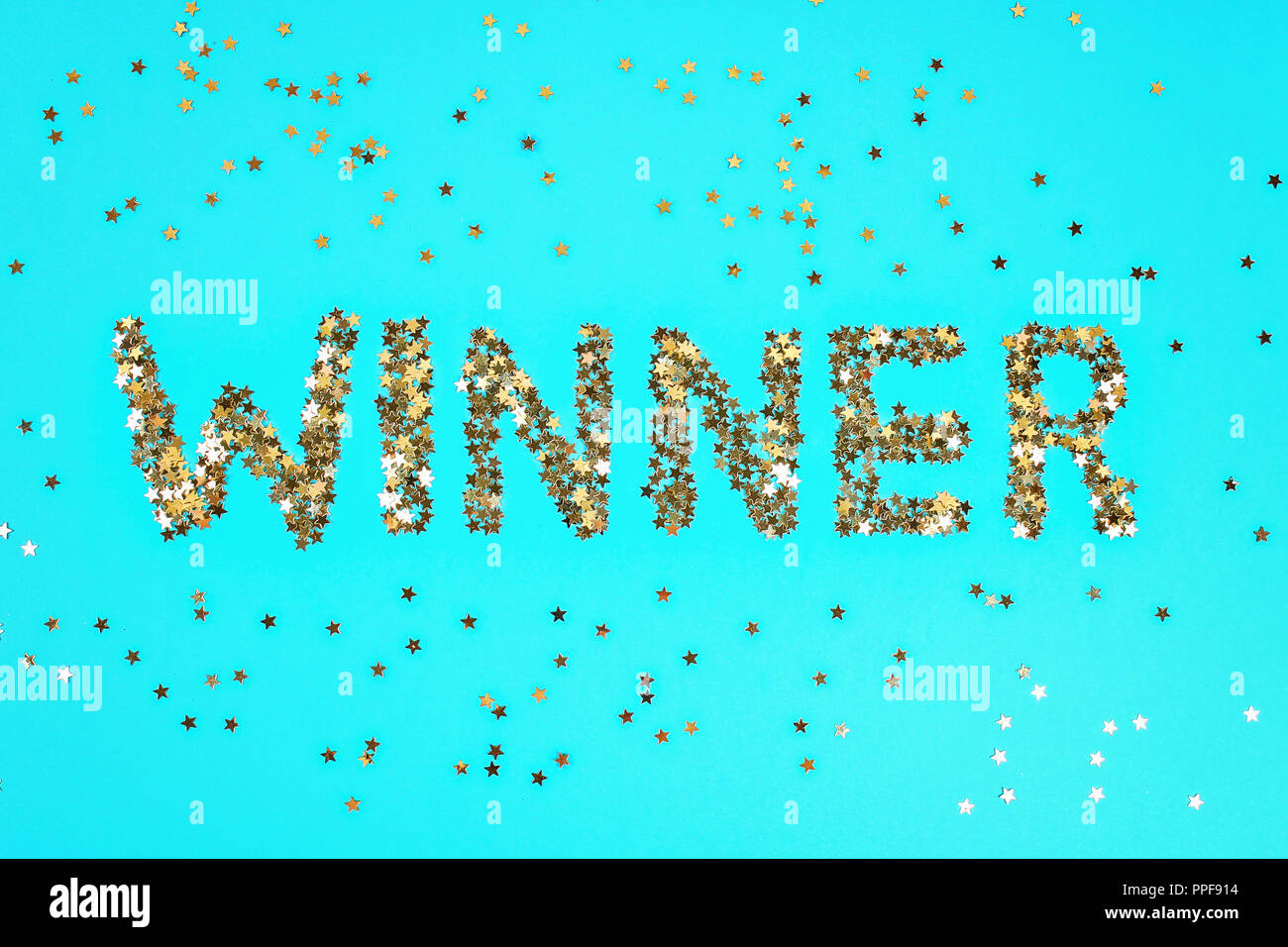 The word Winner is laid out of starry confetti on a blue background ...