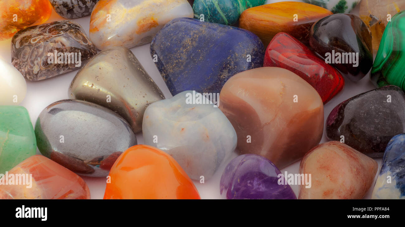 Polished gemstones background. Close-up photo of tumbled semi-precious ...