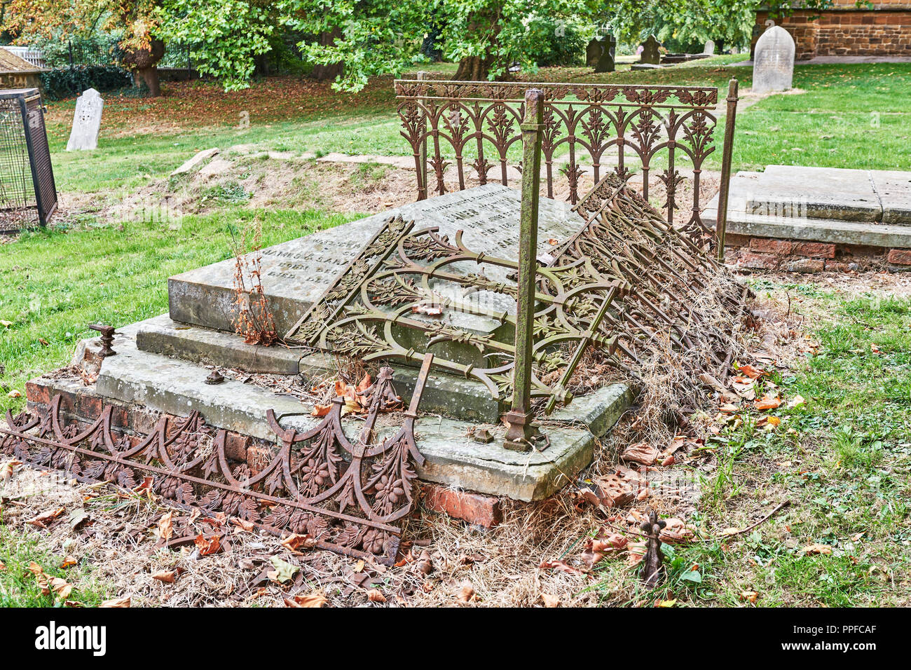 Decaying tomb railings around a burial in the graveyard at the norman ...