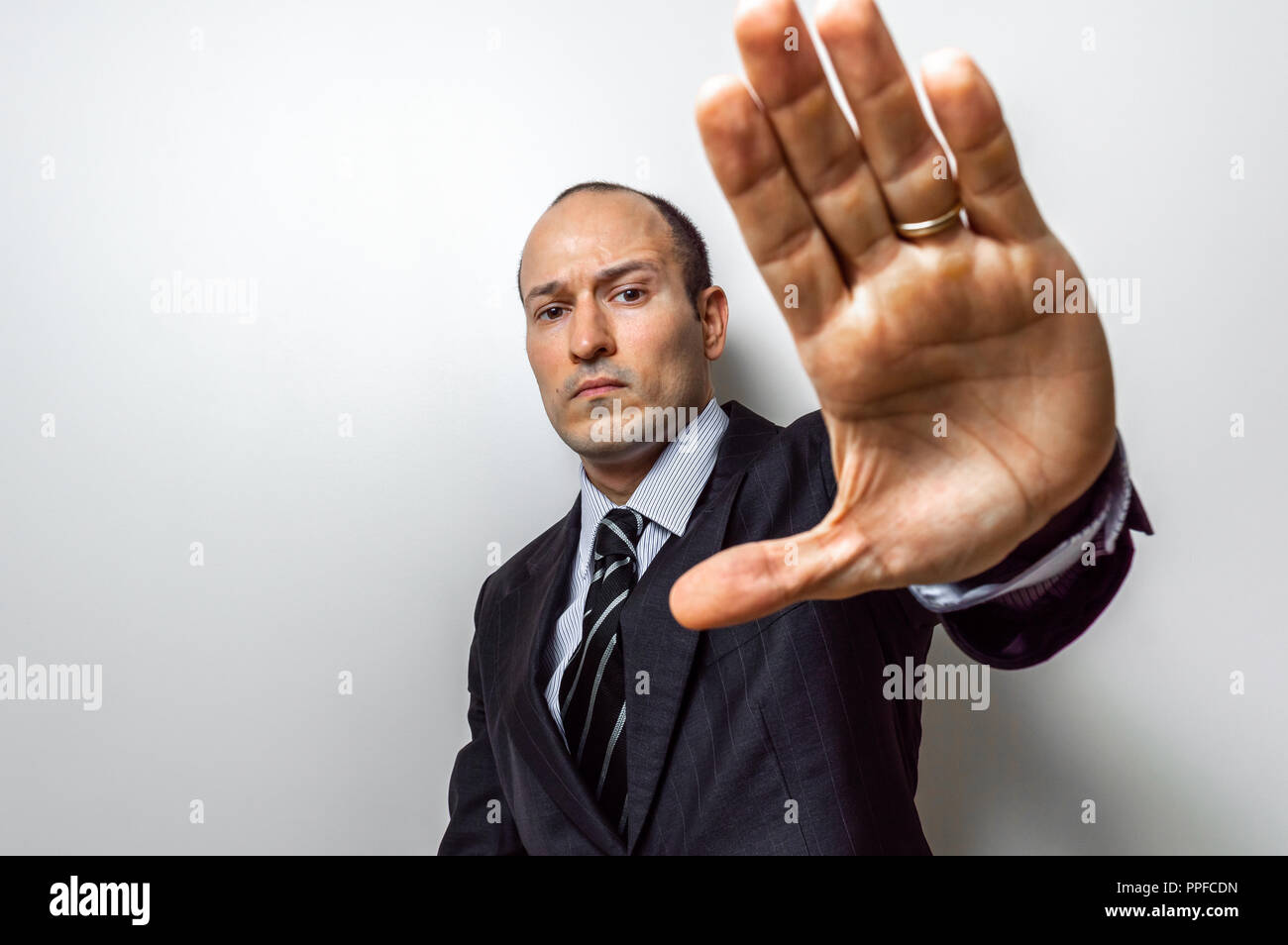 Young man on suit making a stop gesture Stock Photo - Alamy