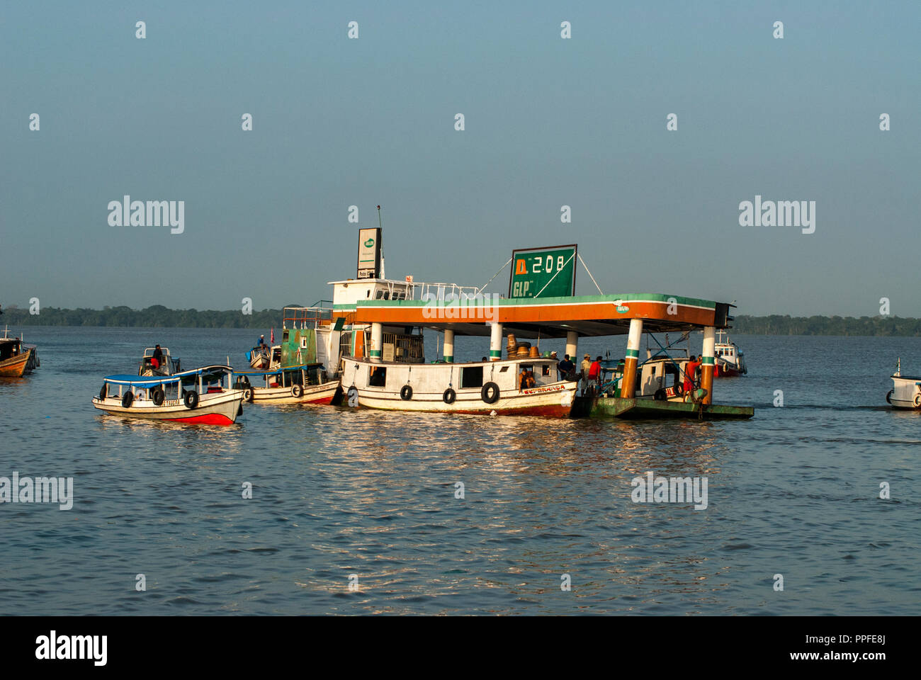 Golden early morning light on a floating fuel station on the Amazon ...