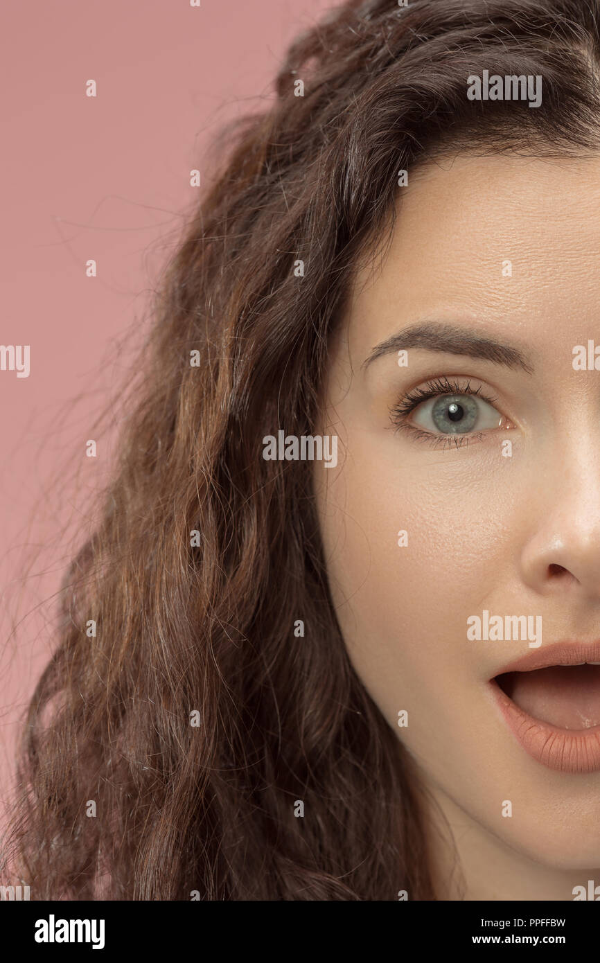 Wow. Beautiful female half face front portrait isolated on pink studio ...