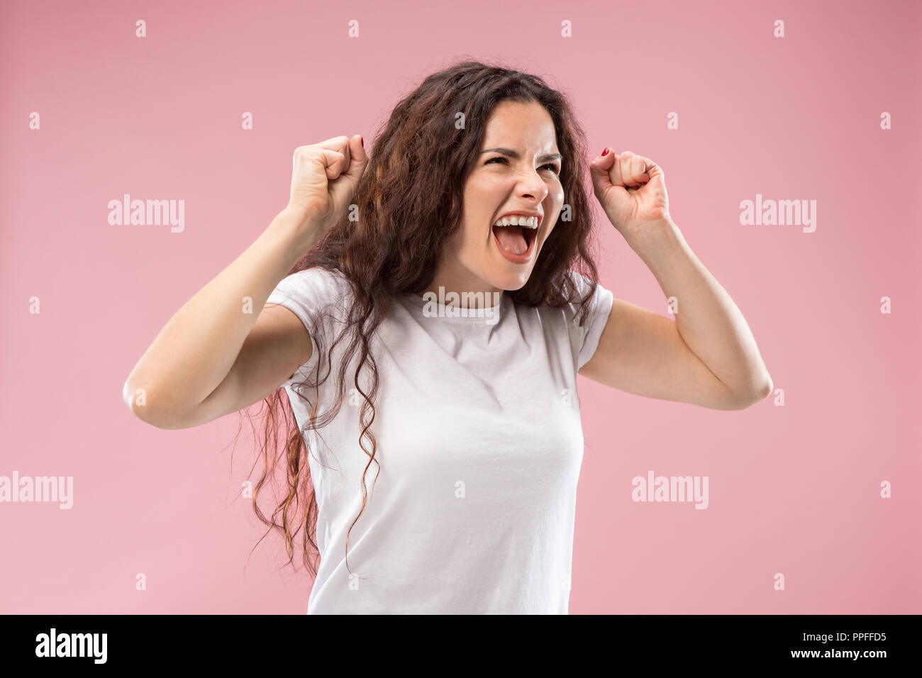 Angry woman. Aggressive business woman standing isolated on trendy pink ...