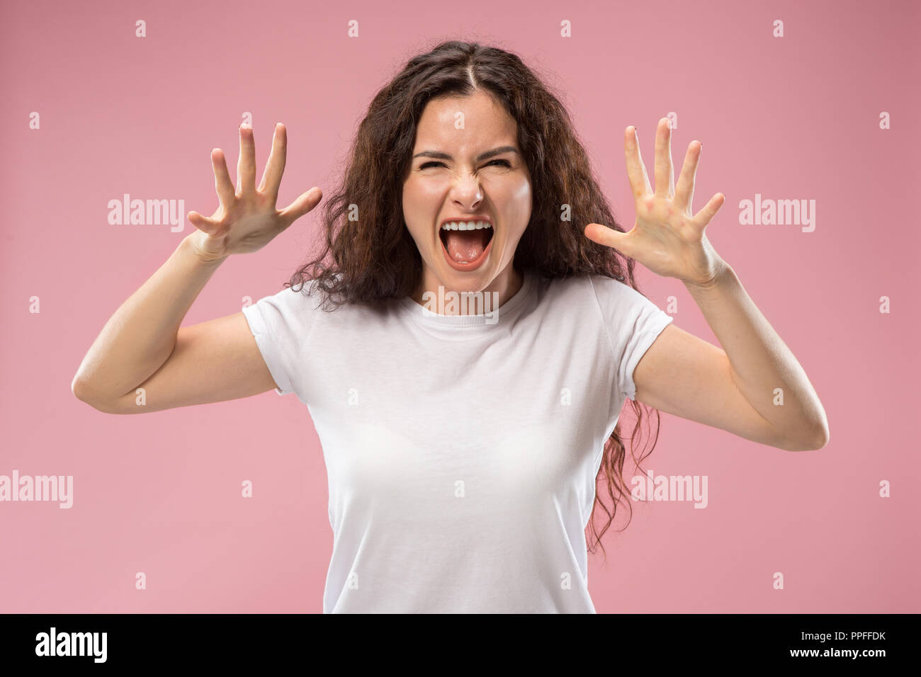 Angry woman. Aggressive business woman standing isolated on trendy pink ...