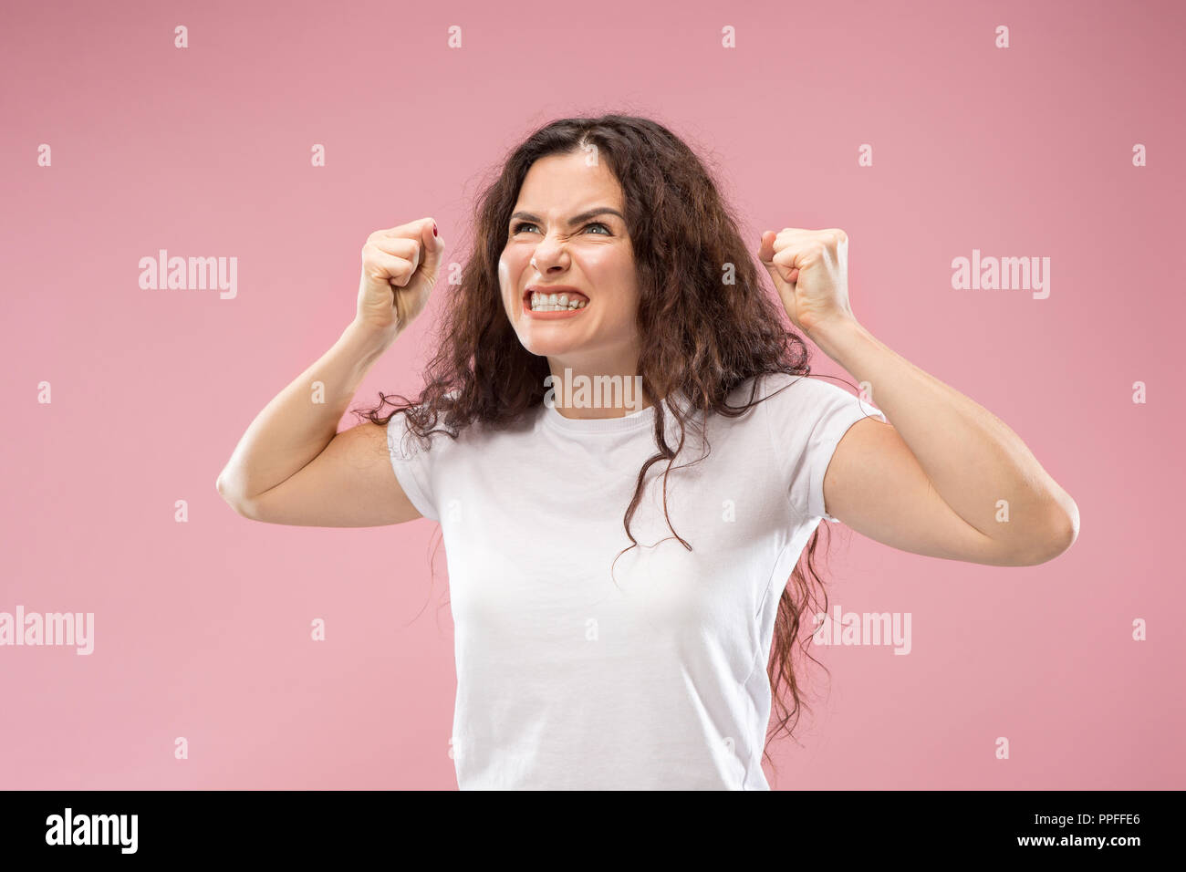 Angry woman. Aggressive business woman standing isolated on trendy pink ...