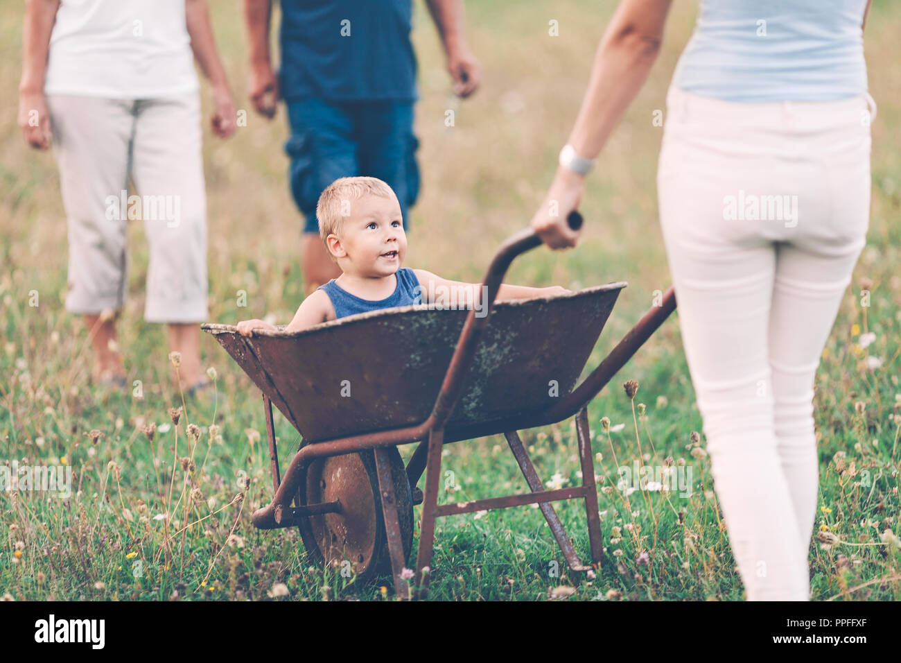 Family pushing their small child and grandchild in a wheelbarrow Stock ...
