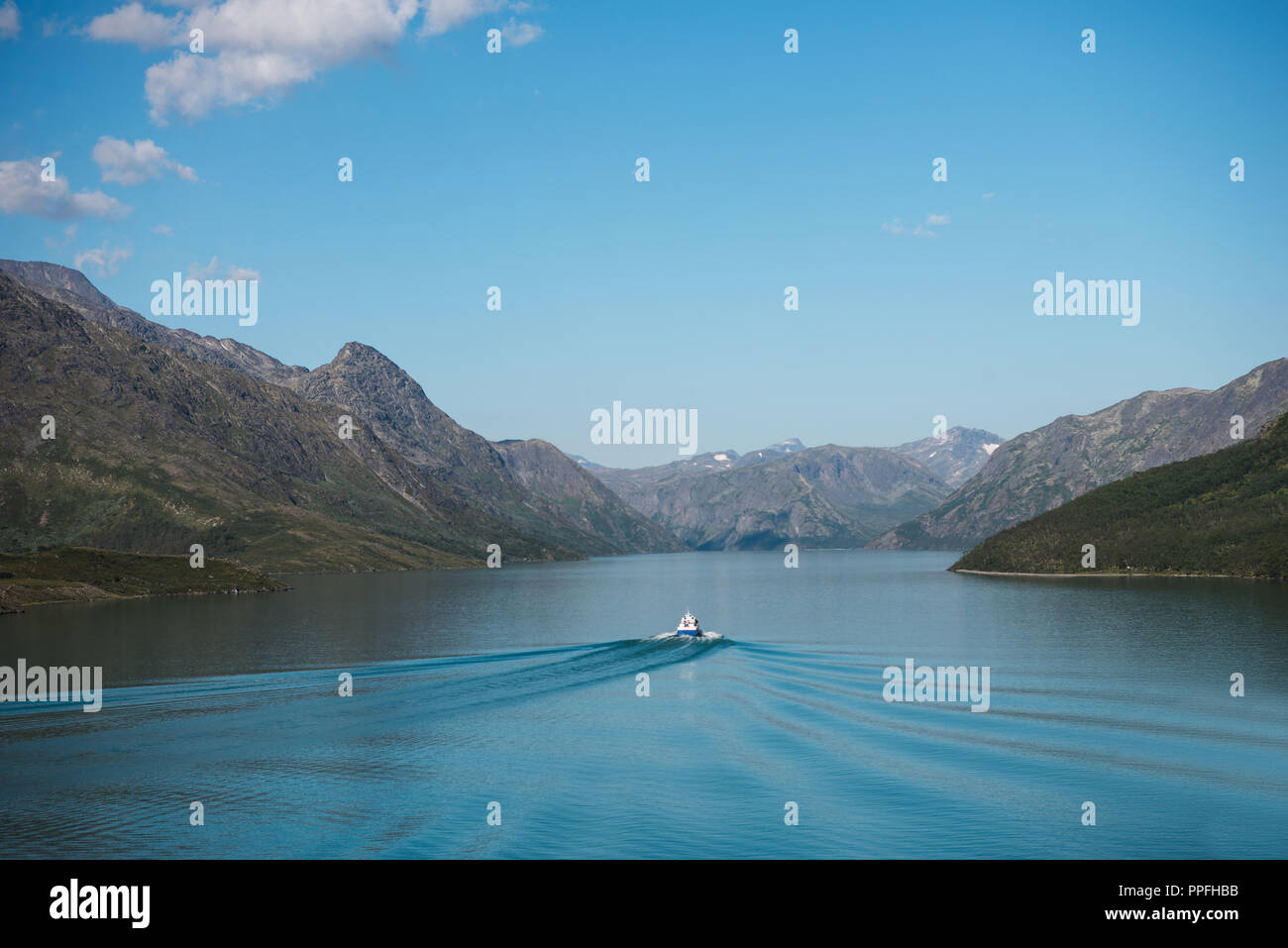 boat floating on calm blue water of Gjende lake, Besseggen ridge ...
