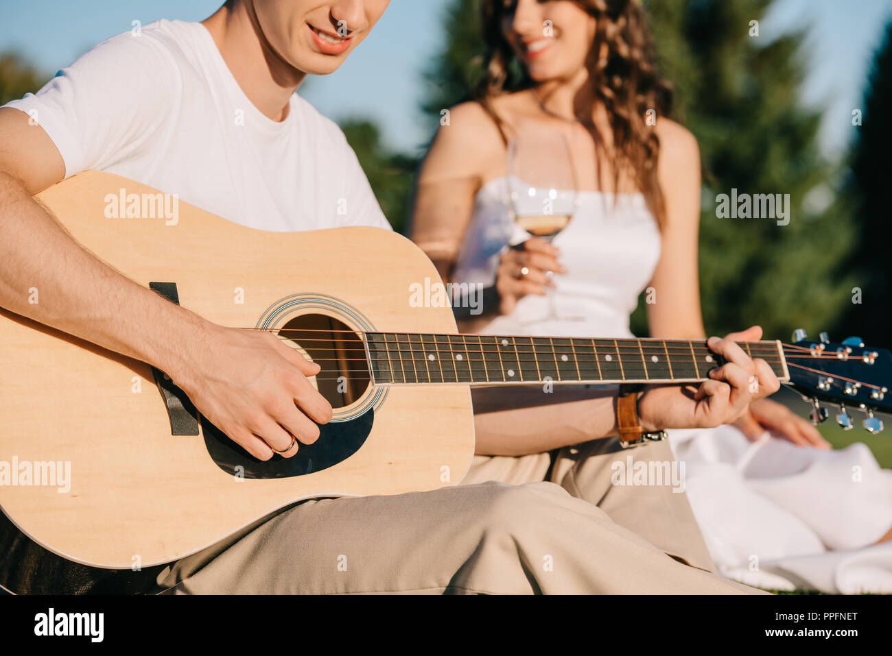 groom playing on acoustic guitar for bride with glass of wine Stock ...