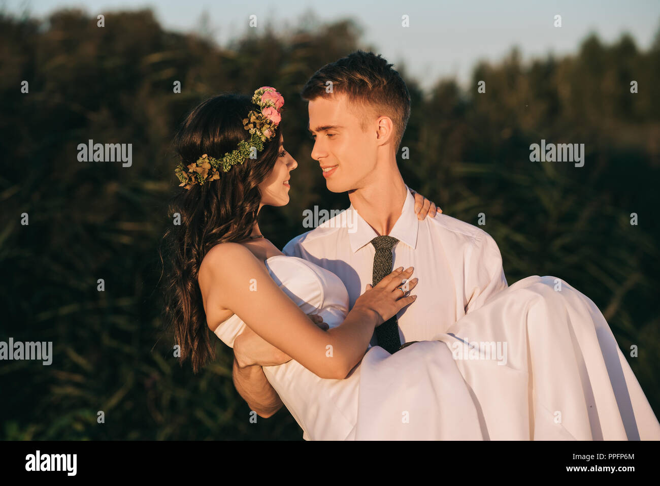 Handsome groom carrying bride hi-res stock photography and images - Alamy
