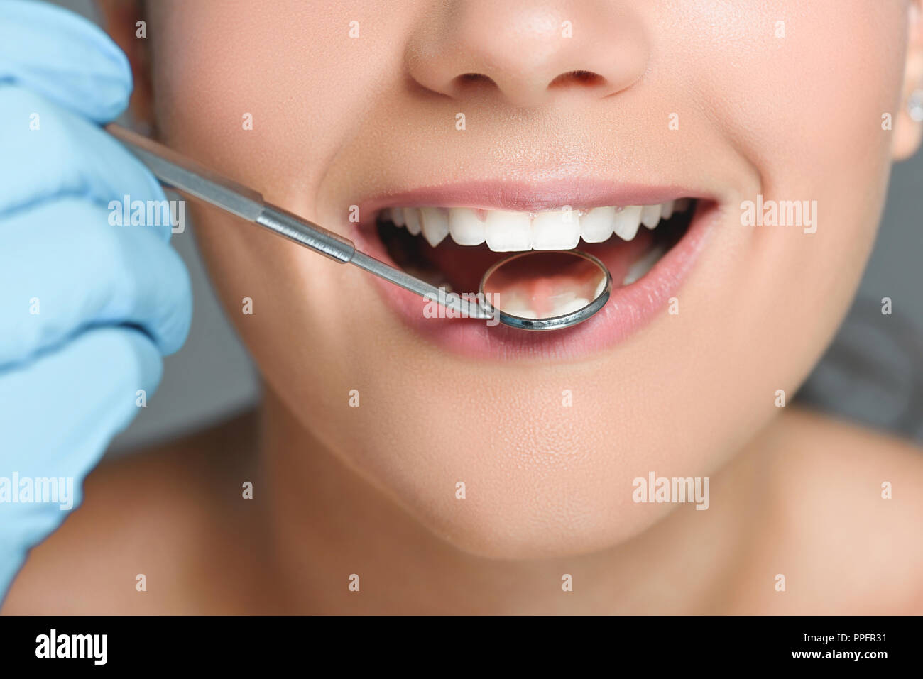 partial view of dentist with dental mirror checking womans teeth Stock ...