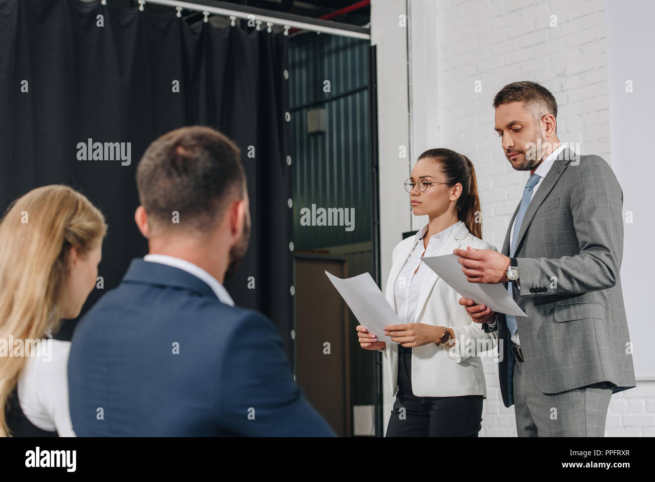 business trainers standing on stage with documents in hub Stock Photo ...