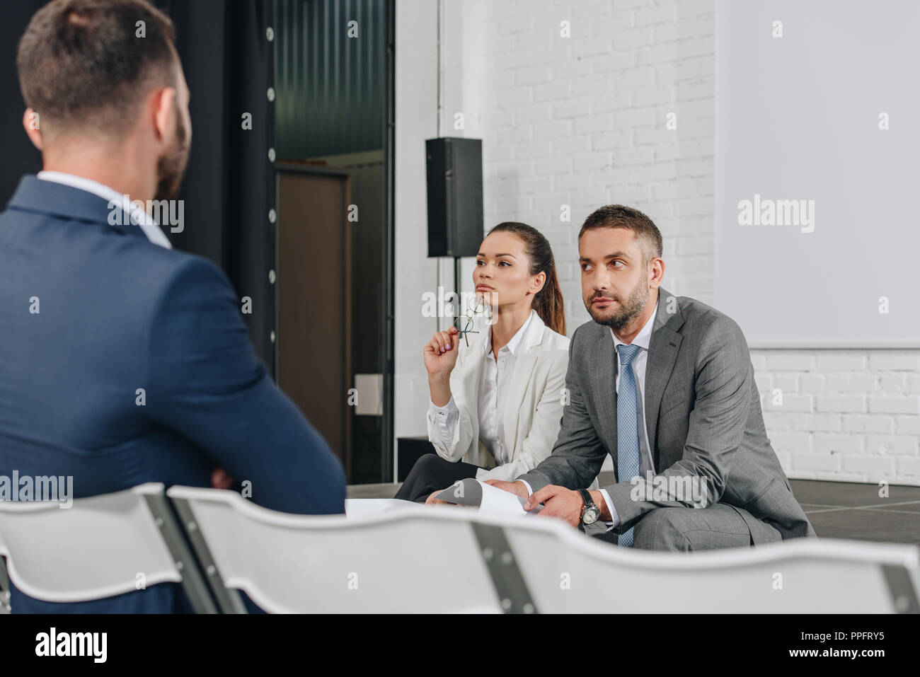 business trainers sitting on stage with documents in hub Stock Photo ...