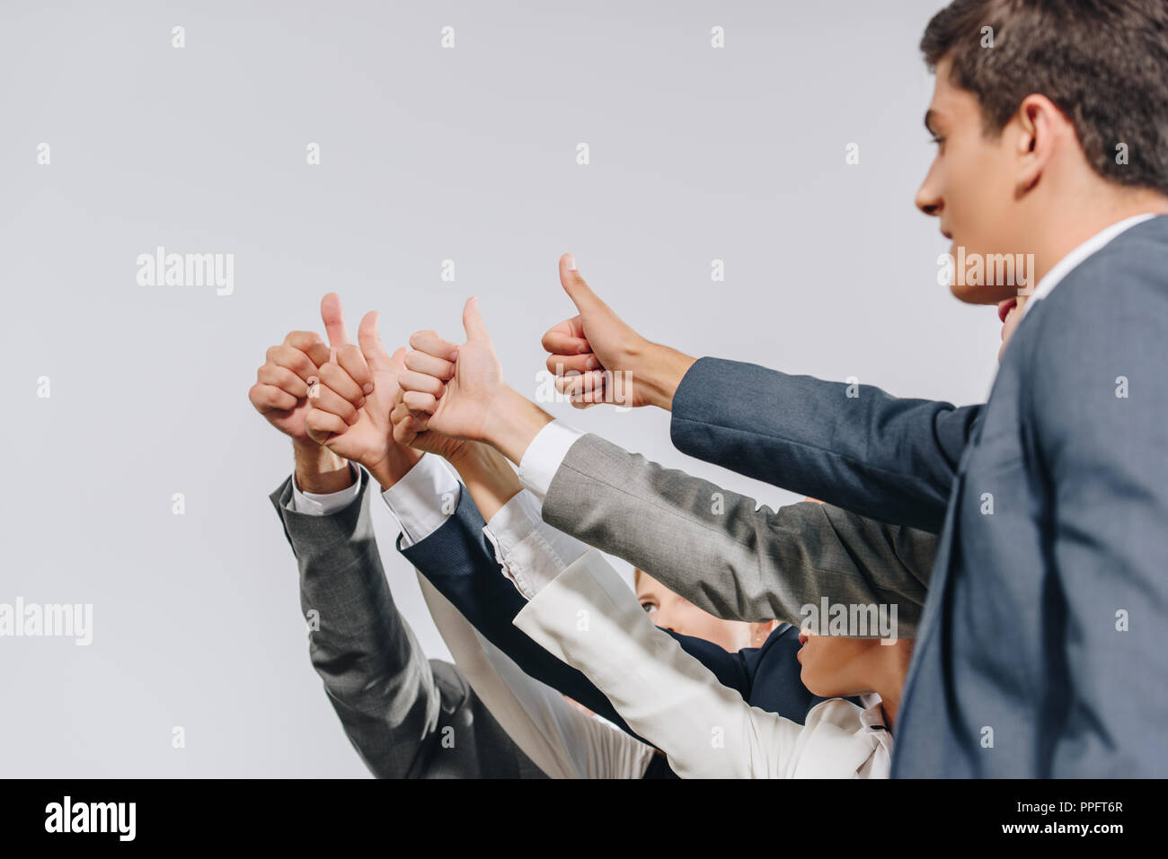 businesspeople in formal wear showing thumbs up in hub Stock Photo - Alamy