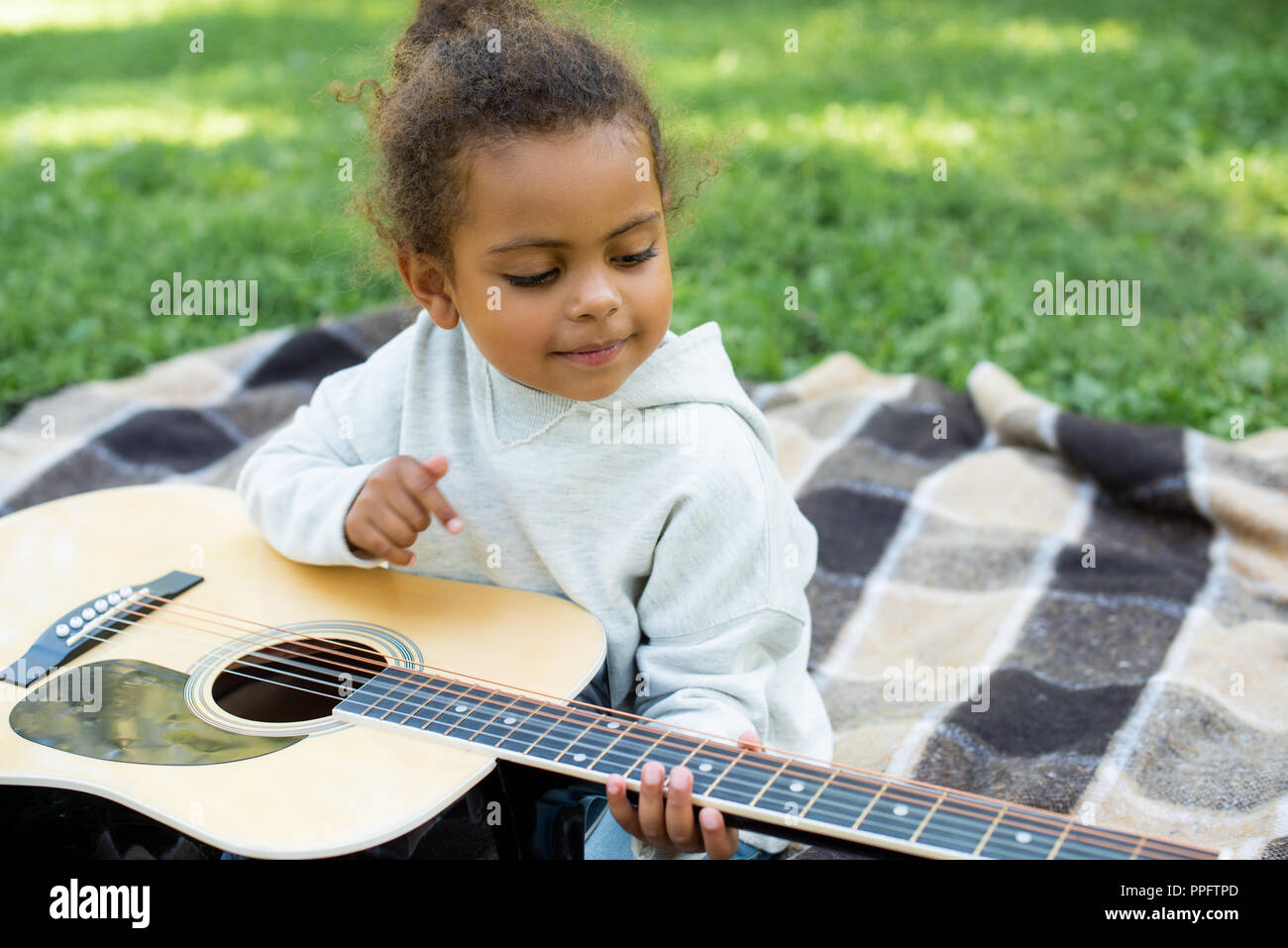 adorable african american kid playing acoustic guitar in park Stock ...