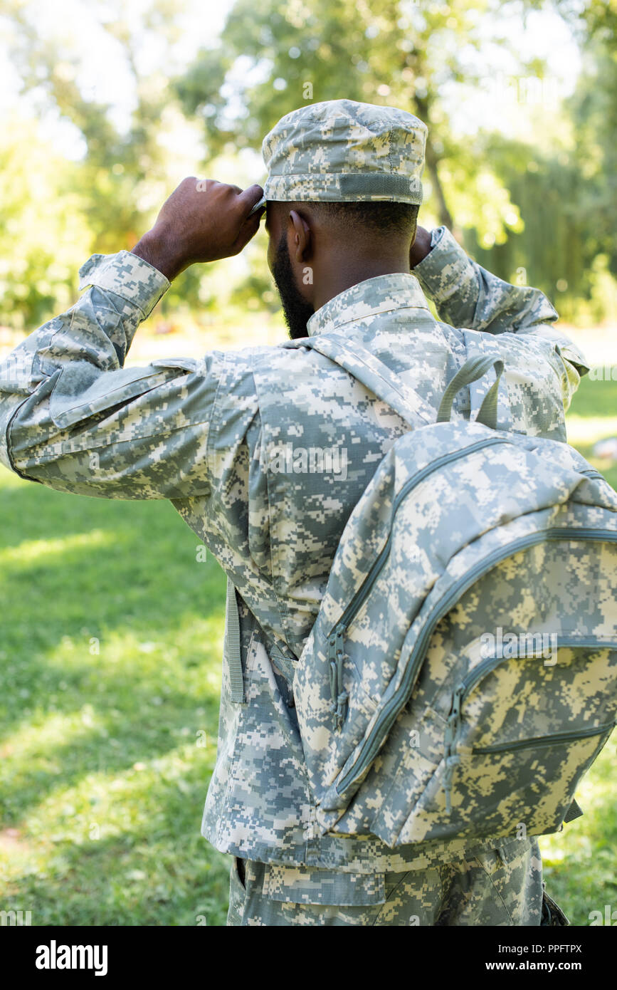 back view of african american soldier in military uniform and bag ...