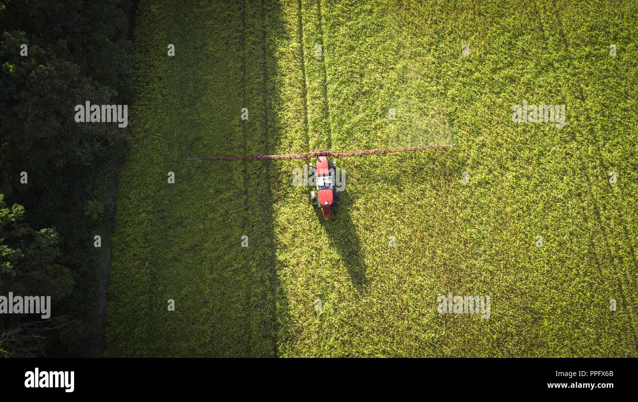 Agricultural machinery in the field. Tractor with a sprayer. Aerial ...
